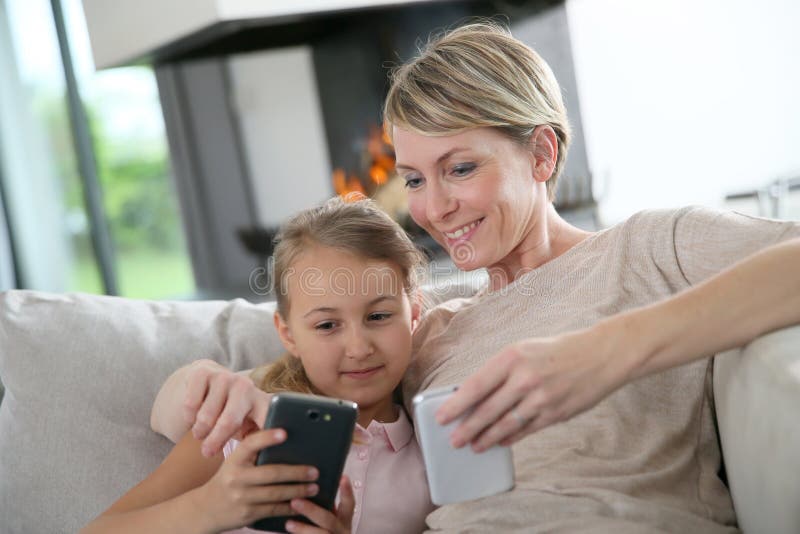 Mother and Daughter Using Smartphones Stock Photo - Image of complicity ...