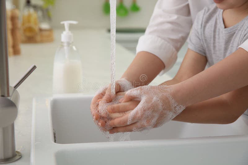 Mother and Daughter Washing Hands with Liquid Soap Together in Kitchen ... Mother and Daughter Washing Hands with Liquid Soap Together in Kitchen ...