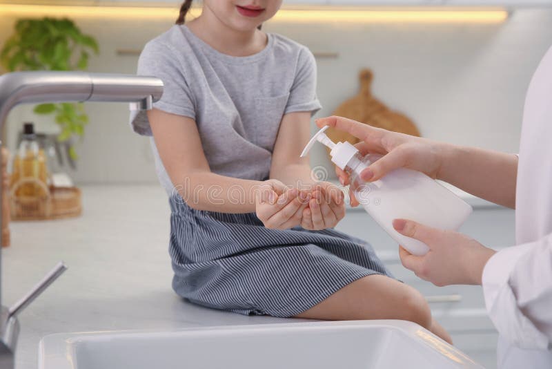 Mother and Daughter Washing Hands with Liquid Soap Together in Kitchen ... Mother and Daughter Washing Hands with Liquid Soap Together in Kitchen ...
