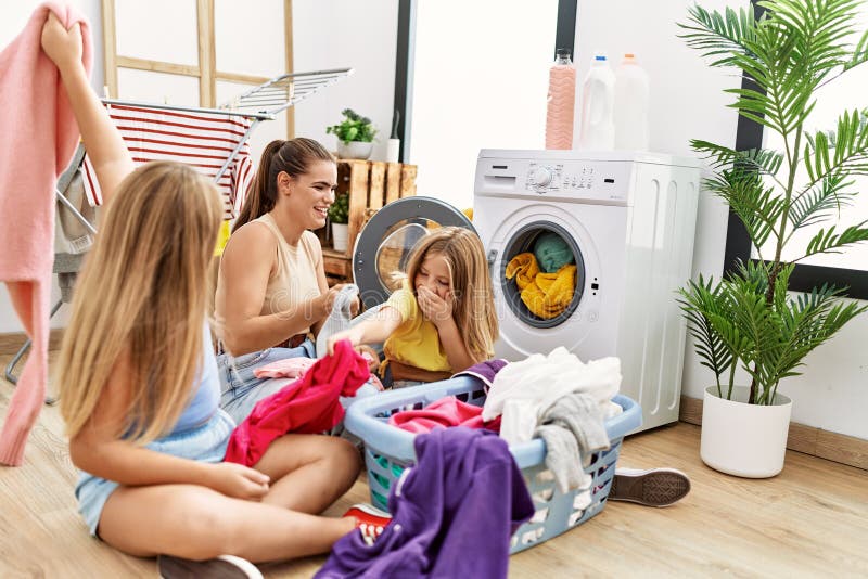 Mother and Daughters Smiling Confident Fighting with Clothes at Laundry ...