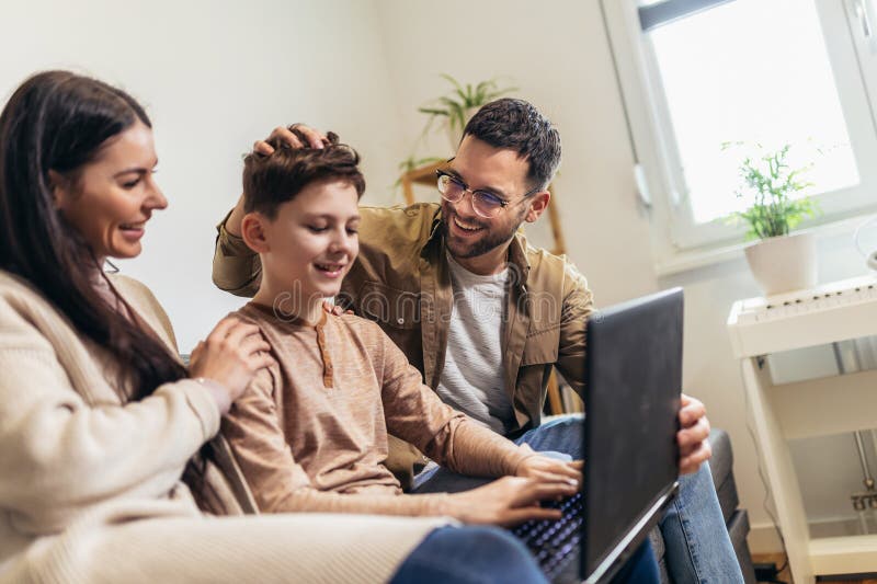 Mother, Father and Son Looking at the Laptop Together Stock Photo ...