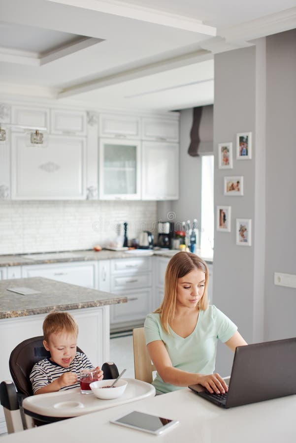 Mother Feeding Child and Working on Computer Stock Photo - Image of ...