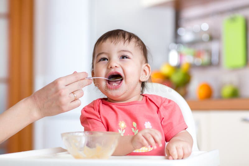 Mother Feeds Funny Baby from a Spoon Stock Photo - Image of breakfast ...