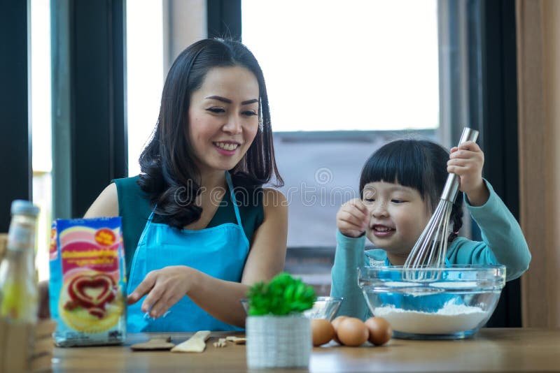 Mother and Girl Help Each Other Make Cakes in the Kitchen at Home Stock ...