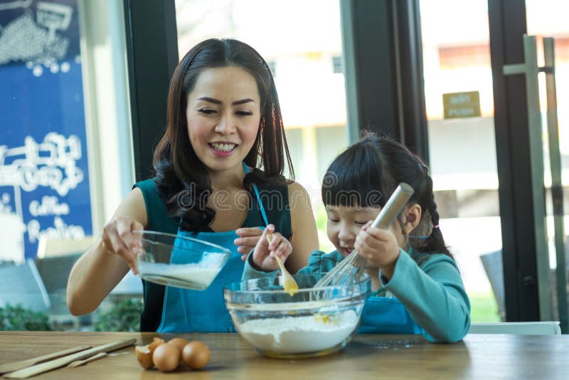 Mother and Girl Help Each Other Make Cakes in the Kitchen at Home Stock ...