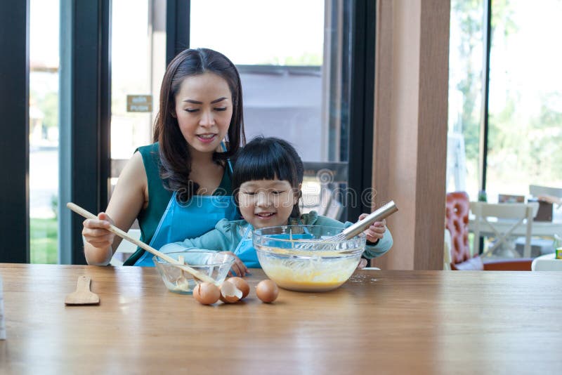 Mother and Girl Help Each Other Make Cakes in the Kitchen at Home Stock ...