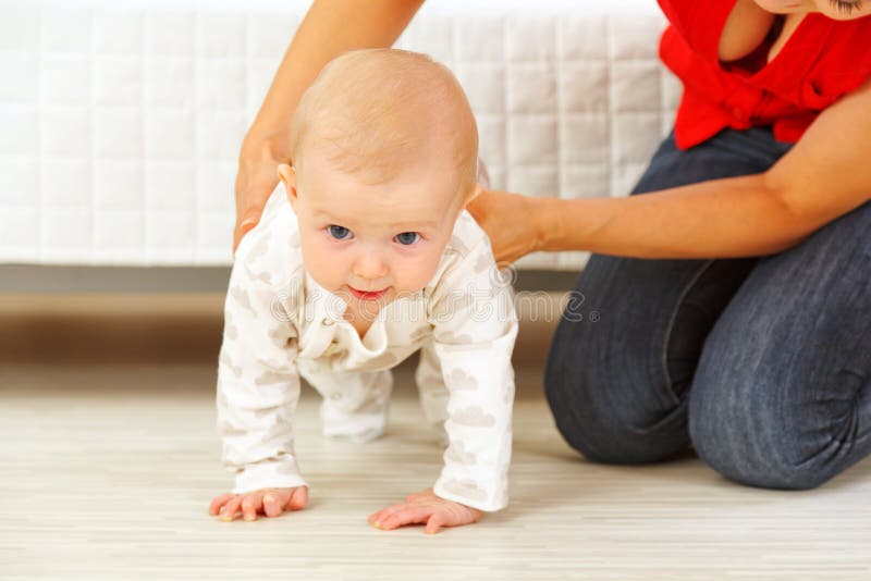 Mother Helping Cheerful Baby Learn To Creep Stock Photo - Image of ...