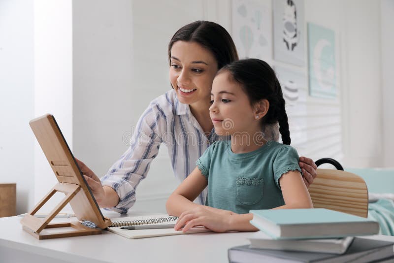 Mother Helping Her Daughter Doing Homework with Tablet Stock Image ...