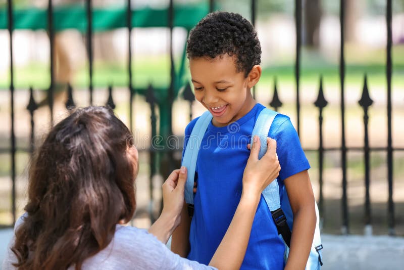 Mother Helping Her Son To Put on Backpack Outdoors Stock Photo - Image ...