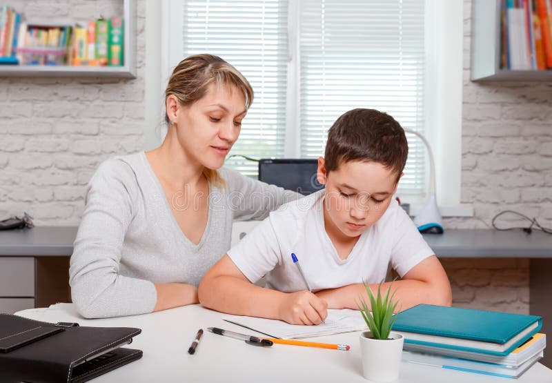 Mother Helps Son To Do Lessons. the Tutor is Engaged with the Child ... Mother Helps Son To Do Lessons. the Tutor is Engaged with the Child ...