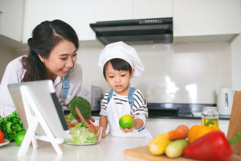 Mother with Her Daughter Preparing Lunch in the Kitchen and Enjoying ...