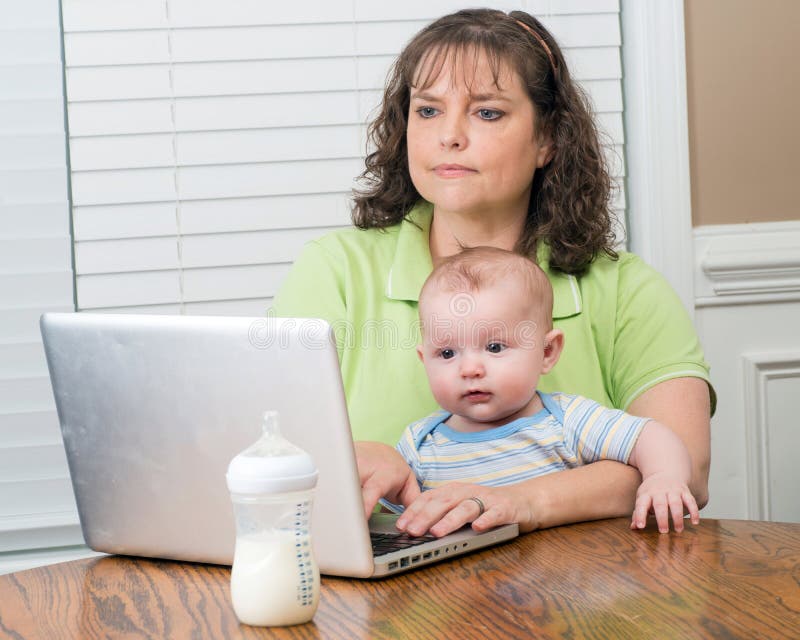 Mother Holding Baby while Working on Computer Stock Image - Image of ...