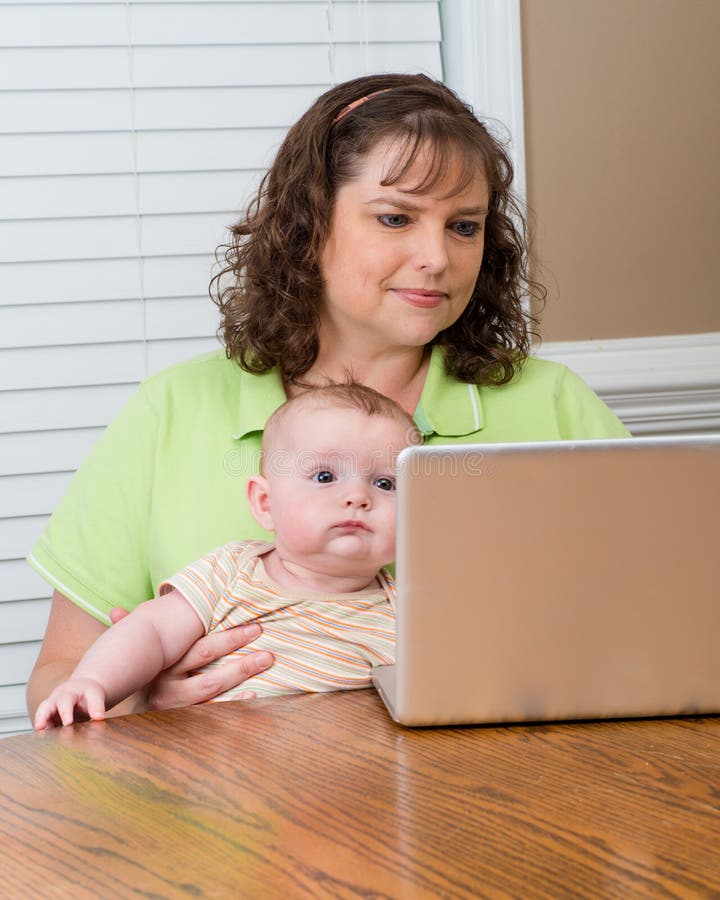 Mother Holding Baby while Working on Computer Stock Photo - Image of ...