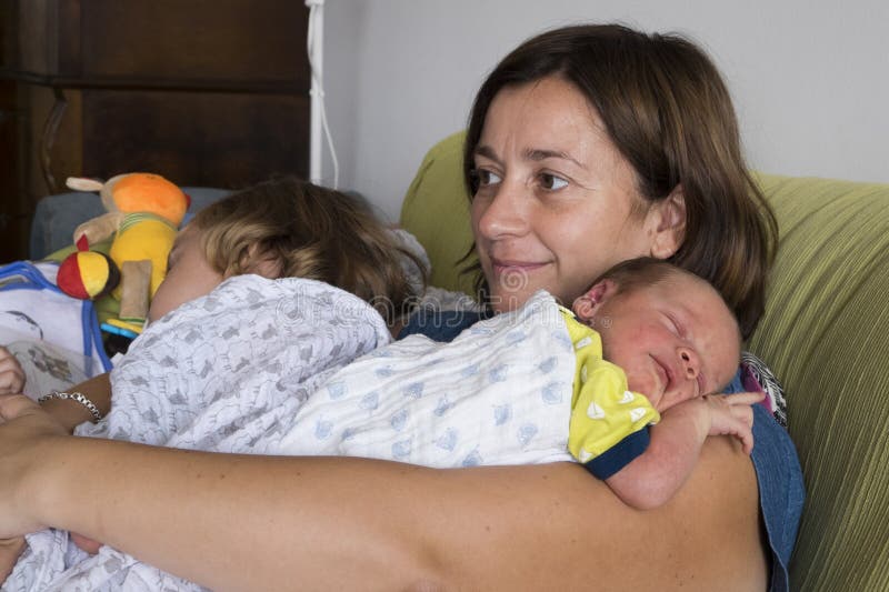 Mother Holding Her Newborn Son And 3 Year Old Daughter In Her Arms