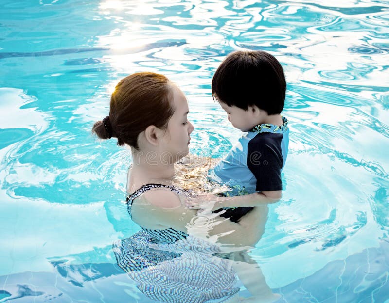 Mother Hugging Her Son in the Swimming Pool at Sunset : Soft Fo Stock ...