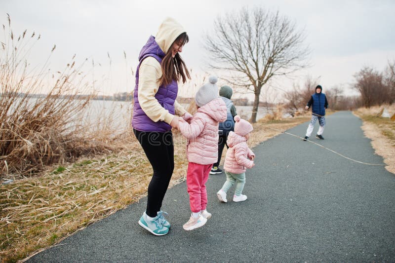 Mother with Kids Jump and Having Fun on the Path by the Lake Stock ...