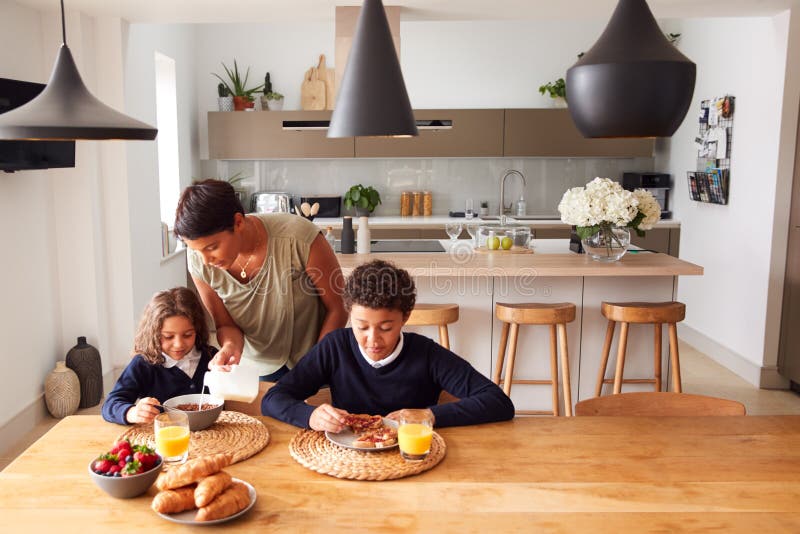 Mother in Kitchen Helping Children with Breakfast before Going To ...