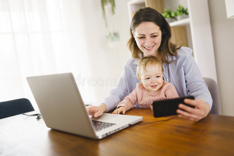 Mother in Kitchen Home Office with Computer and Laptop at Home with Her ...