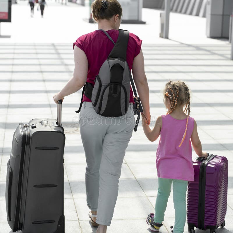 Mother and Little Daughter Go with Suitcases To the Airport. Tourism ... Mother and Little Daughter Go with Suitcases To the Airport. Tourism ...