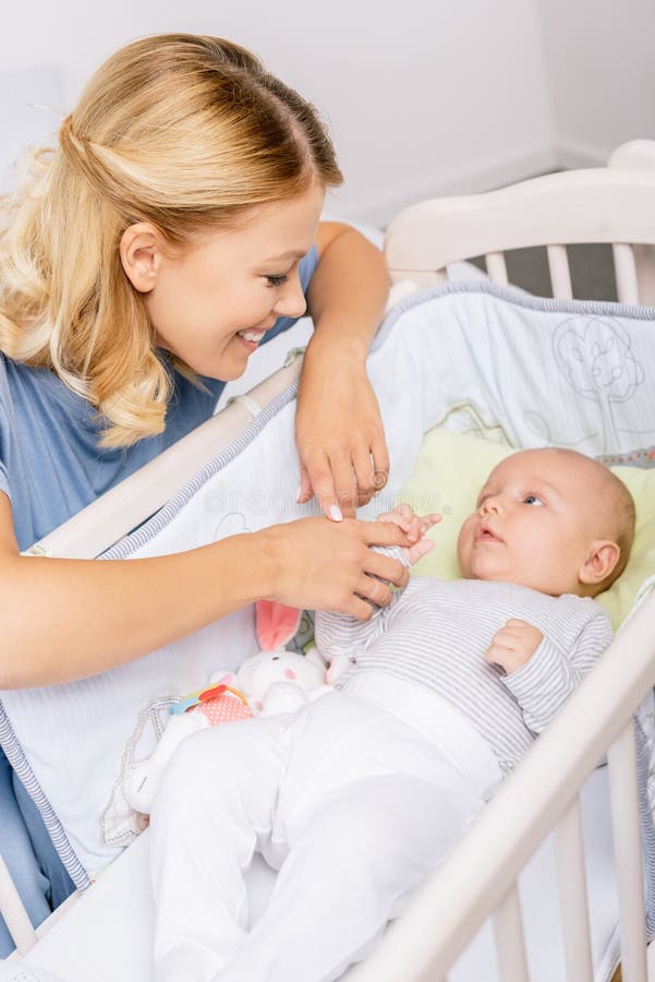 Mother Looking at Baby in Crib Stock Photo - Image of baby, infant ...