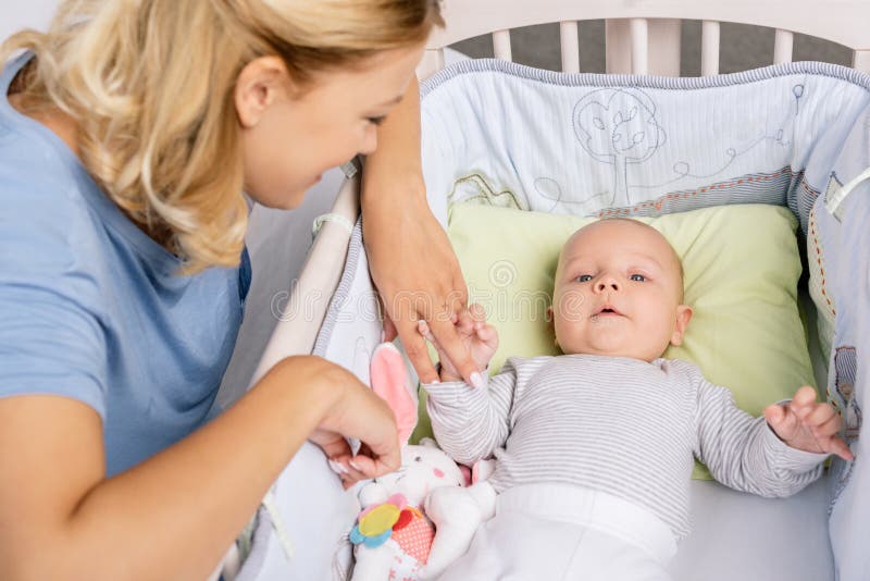 Mother Looking at Baby in Crib Stock Photo - Image of crib ...