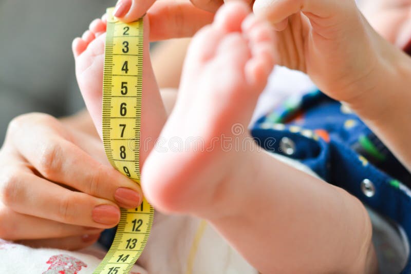 Mother Measuring Tiny Baby Foot with a Meter Stock Image - Image of ...
