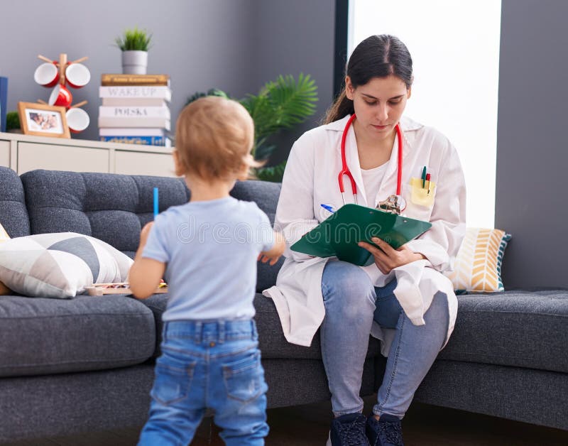 Mother and Son Doctor Writing on Document Examining Child at Home Stock ...