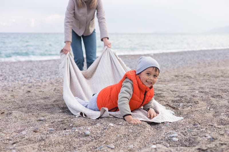 Mother and Son Having Fun on Winter Beach with Blanket Pull Stock Image ...