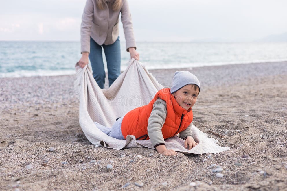 Mother and Son Having Fun on Winter Beach with Blanket Pull Stock Image ...