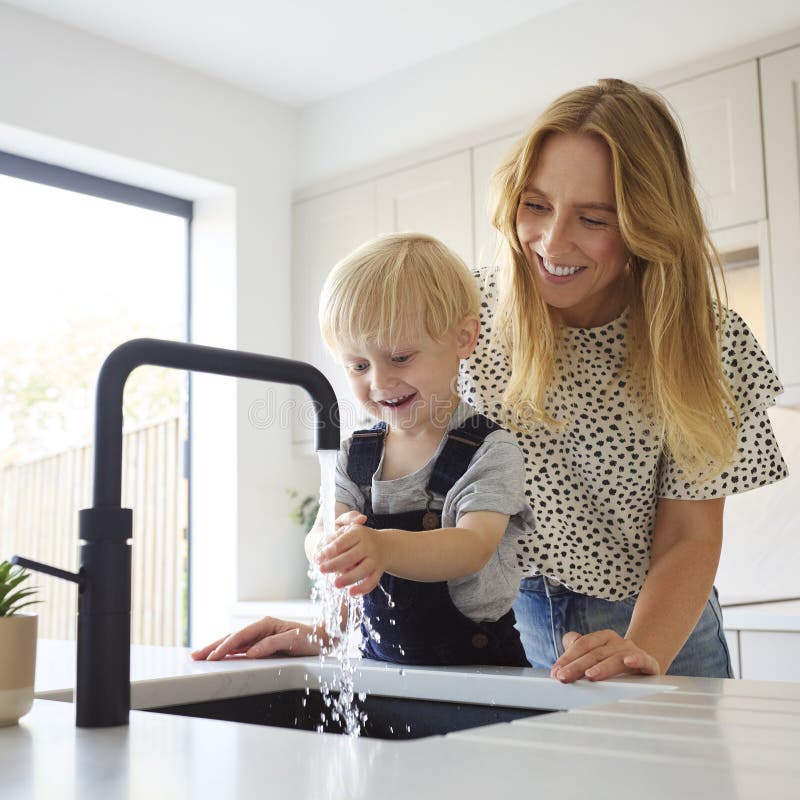 Mother with Son at Home in Kitchen Washing Hands in Sink or Basin ...