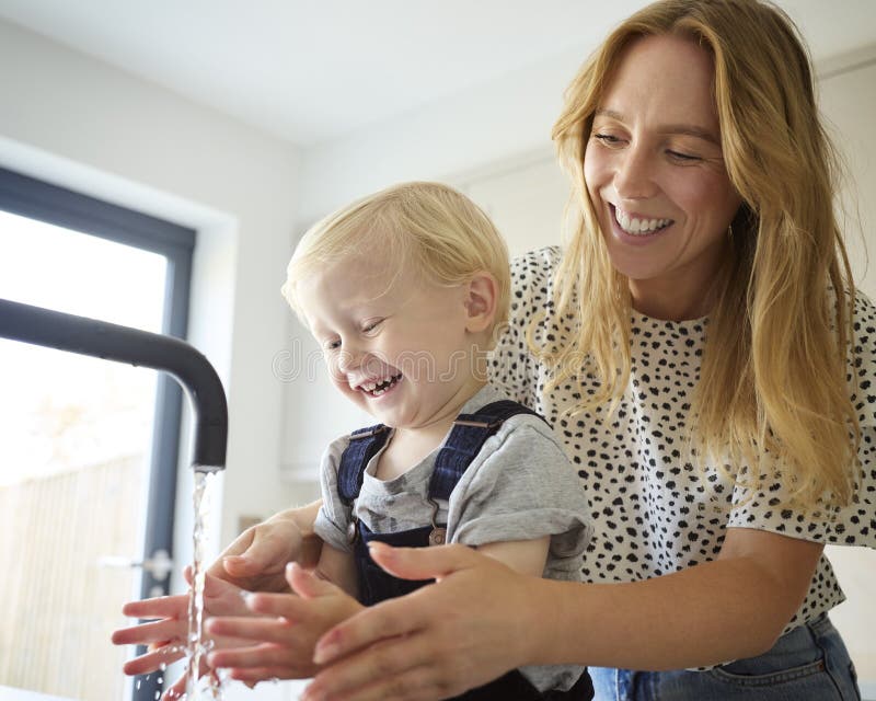 Mother with Son at Home in Kitchen Washing Hands in Sink or Basin ...