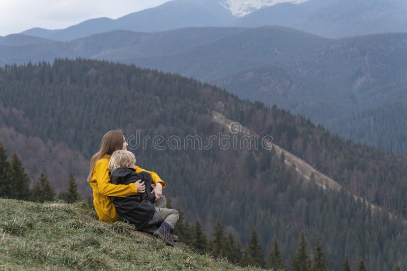 Mother and Son Rest and Sit in an Embrace on Mountains Background ...