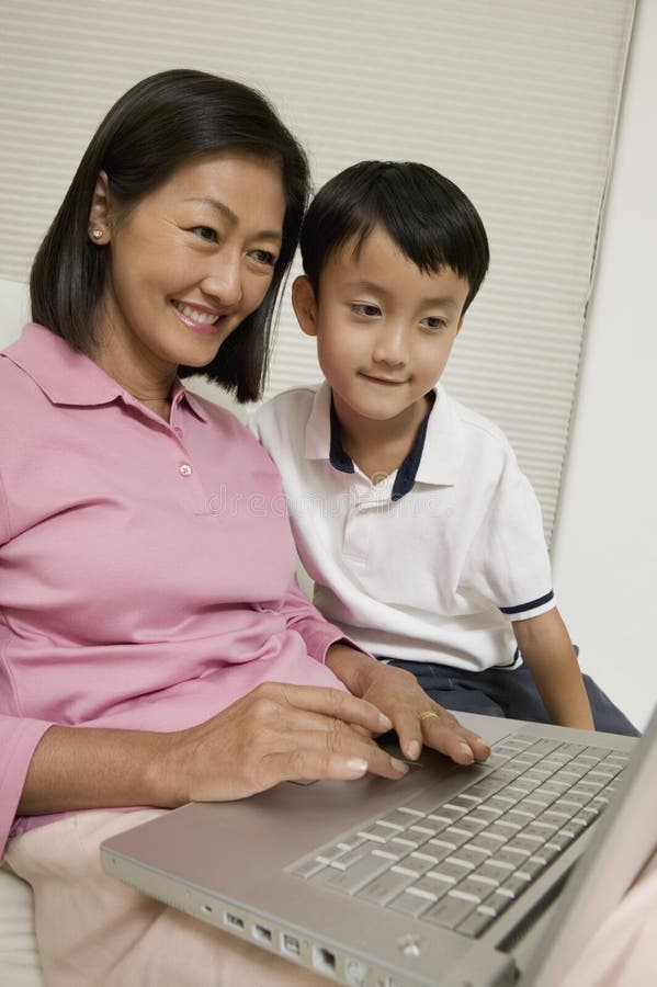 Mother and Son Using Laptop in Living Room Stock Photo - Image of ...