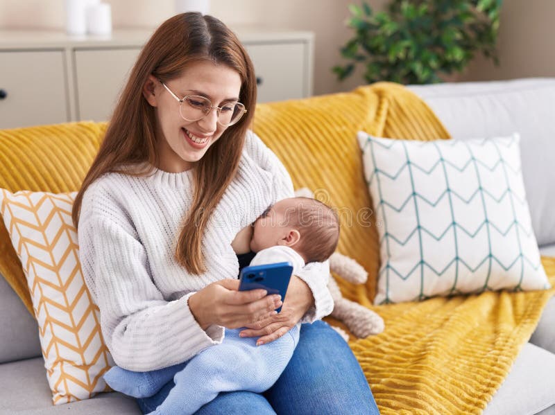 Mother and Son Using Smartphone Breastfeeding Baby at Home Stock Image ...