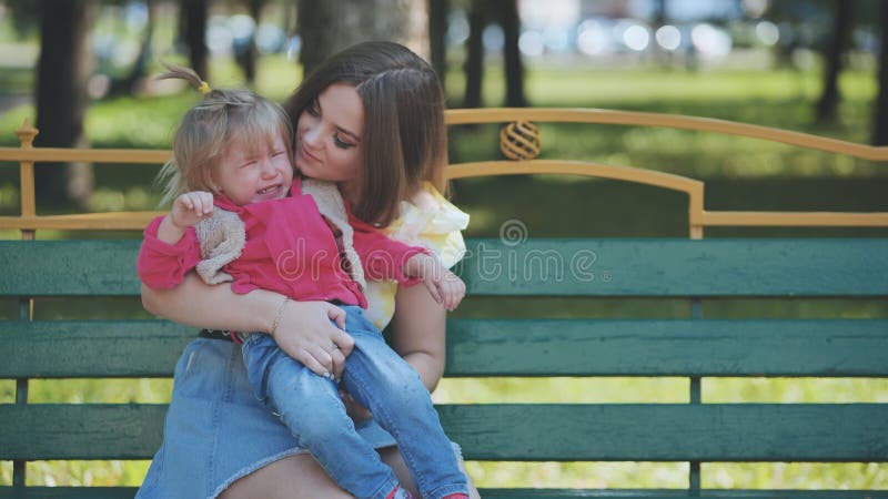 A Mother Soothes a Crying Baby in the Park. Stock Video - Video of ...