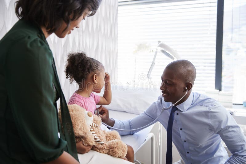 Mother Taking Daughter For Medical Exam In Doctors Office Stock Image