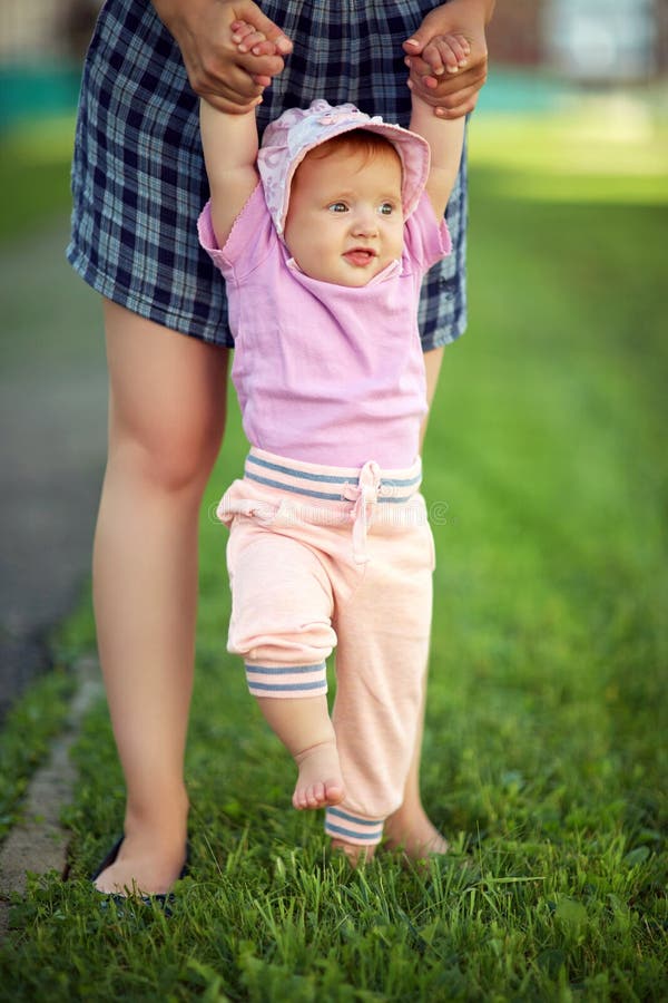 Mother Teaching Her Baby To Take the First Steps Barefoot on Grass ...