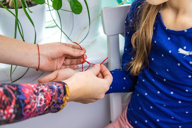 The Mother Ties a Red Thread To the Child Hand. Selective Focus Stock ...