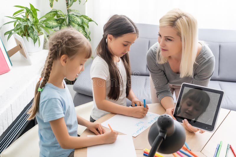 Mother and Two Daughters Doing Homework Writing and Reading at Home ...