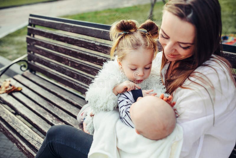 Mother and Two Daughters Rest on a Bench Stock Photo - Image of bench ...