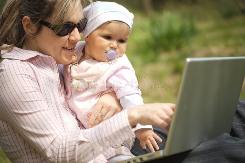 Mother uses a laptop stock photo. Image of mother, care - 2235446