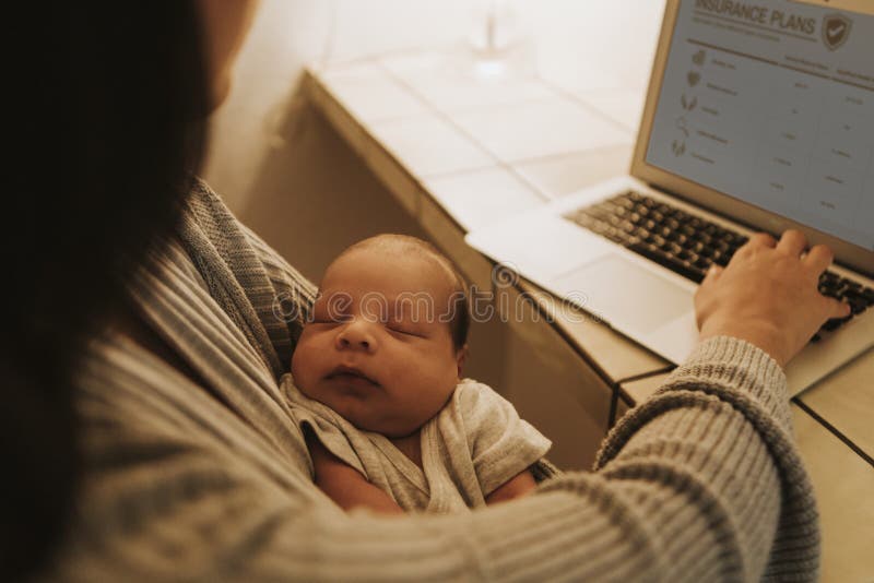 Mother Using a Computer and Holding Her Baby Stock Image - Image of ...