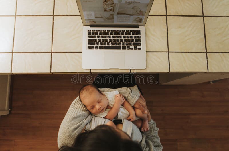 Mother Using a Computer and Holding Her Baby Stock Image - Image of ...