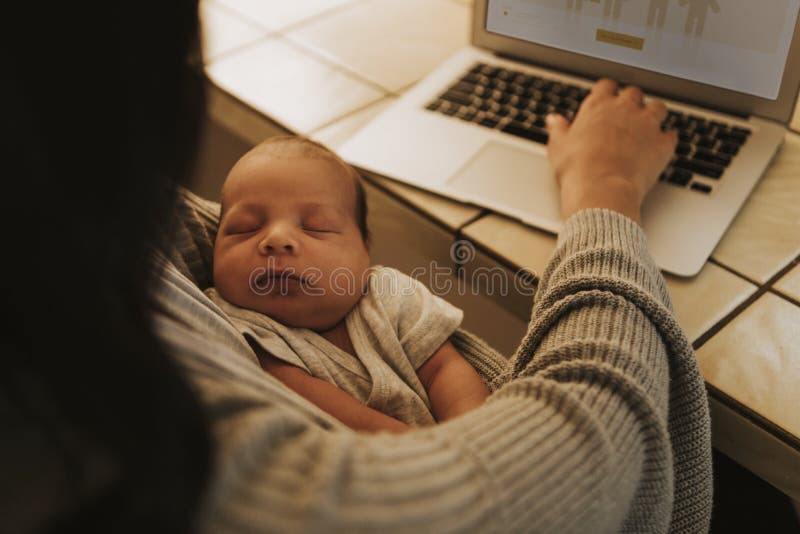 Mother Using a Computer and Holding Her Baby Stock Photo - Image of ...