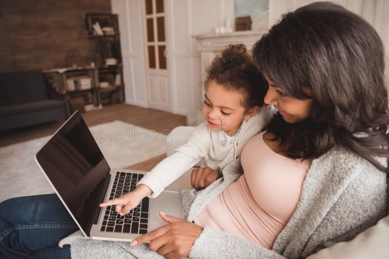 Mother Using Laptop and Cute Little Daughter Pointing at Blank Screen ...