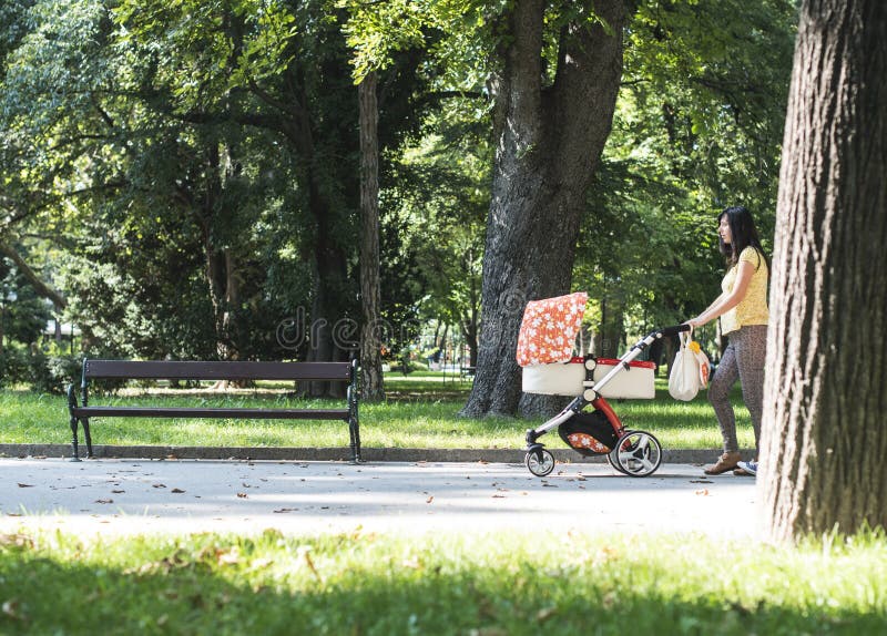Mother Walking in the Park with Baby Buggy Stock Image - Image of happy ...