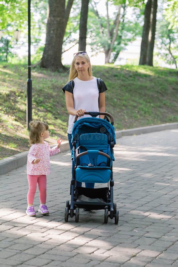 Mother Walking while Pushing a Stroller in the Park Stock Image - Image ...