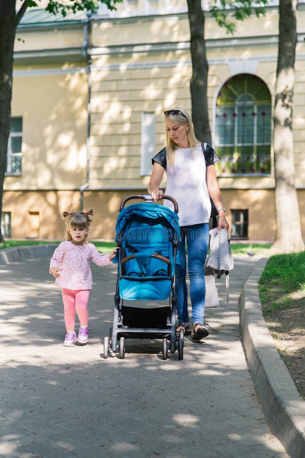 Mother Walking while Pushing a Stroller in the Park Stock Image - Image ...