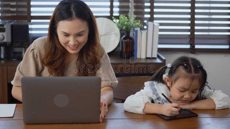 Mother Working with Laptop Computer at Home and Help Daughter Doing ...