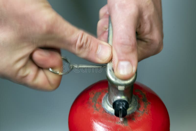 Motion Blur. a Man Pulls Out a Protective Pin from a Fire Extinguisher ...